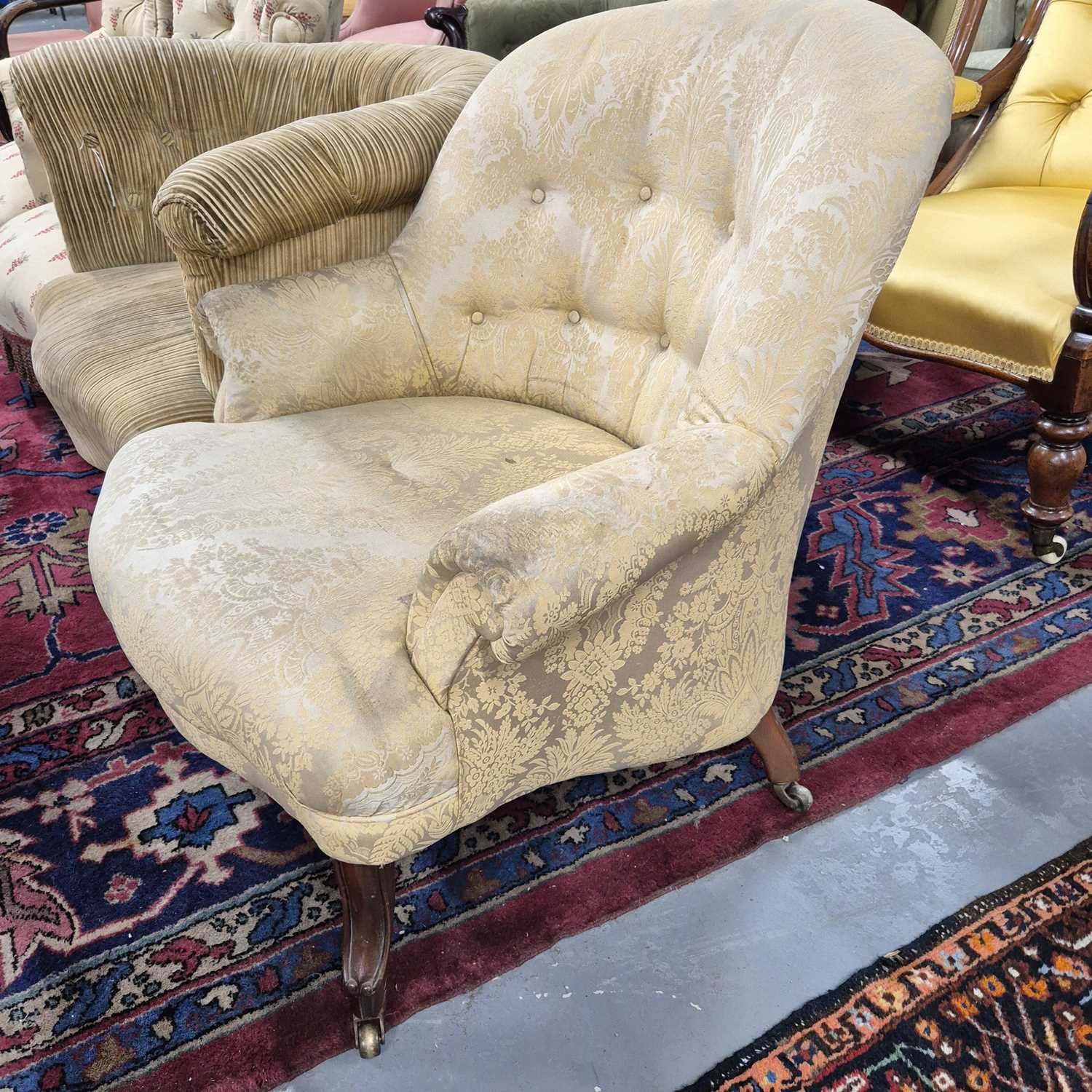 Lot 24 - A Victorian button back armchair with shaped